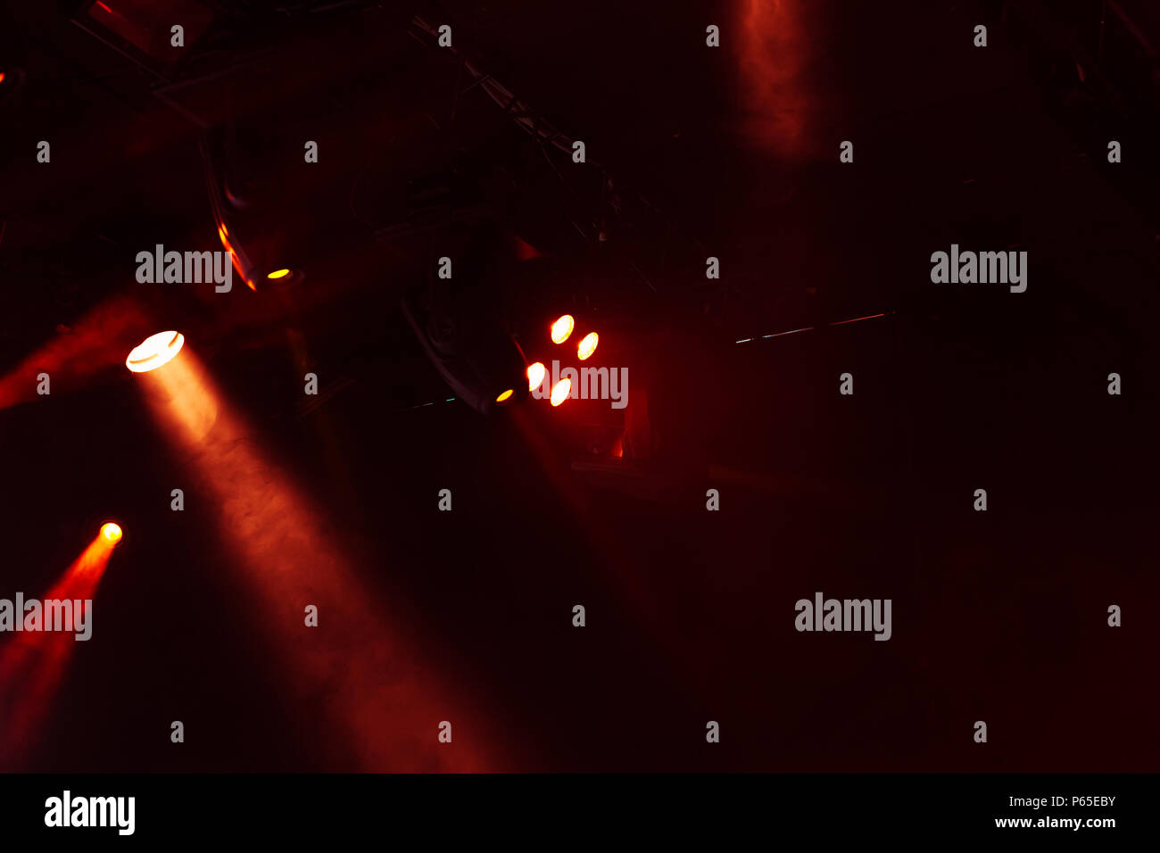 Red scenic lights, strong spot beams in smoke over dark background ...