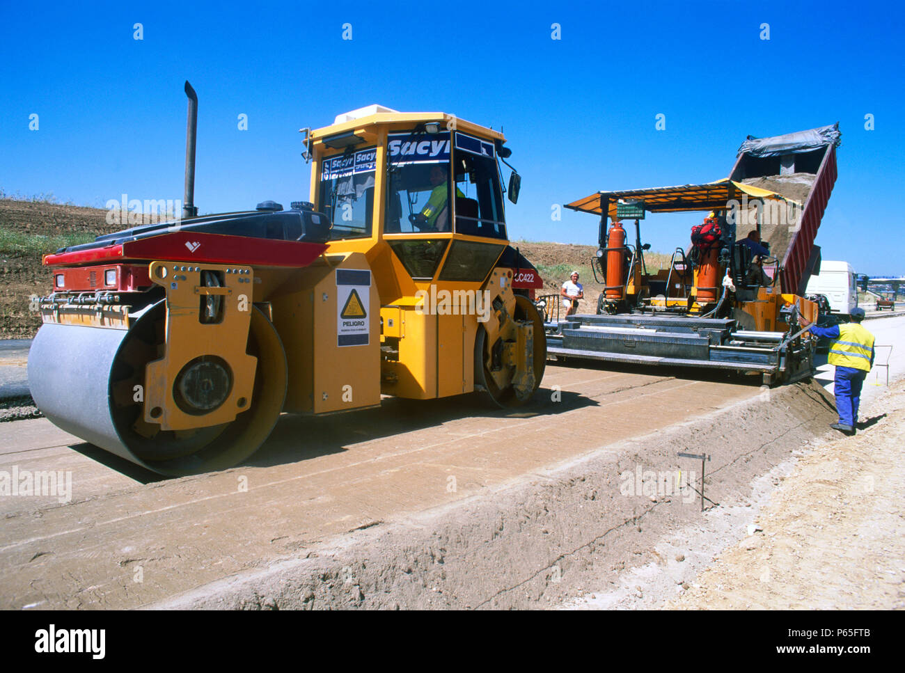 The base course or underlayer is placed by a paving machine and ...