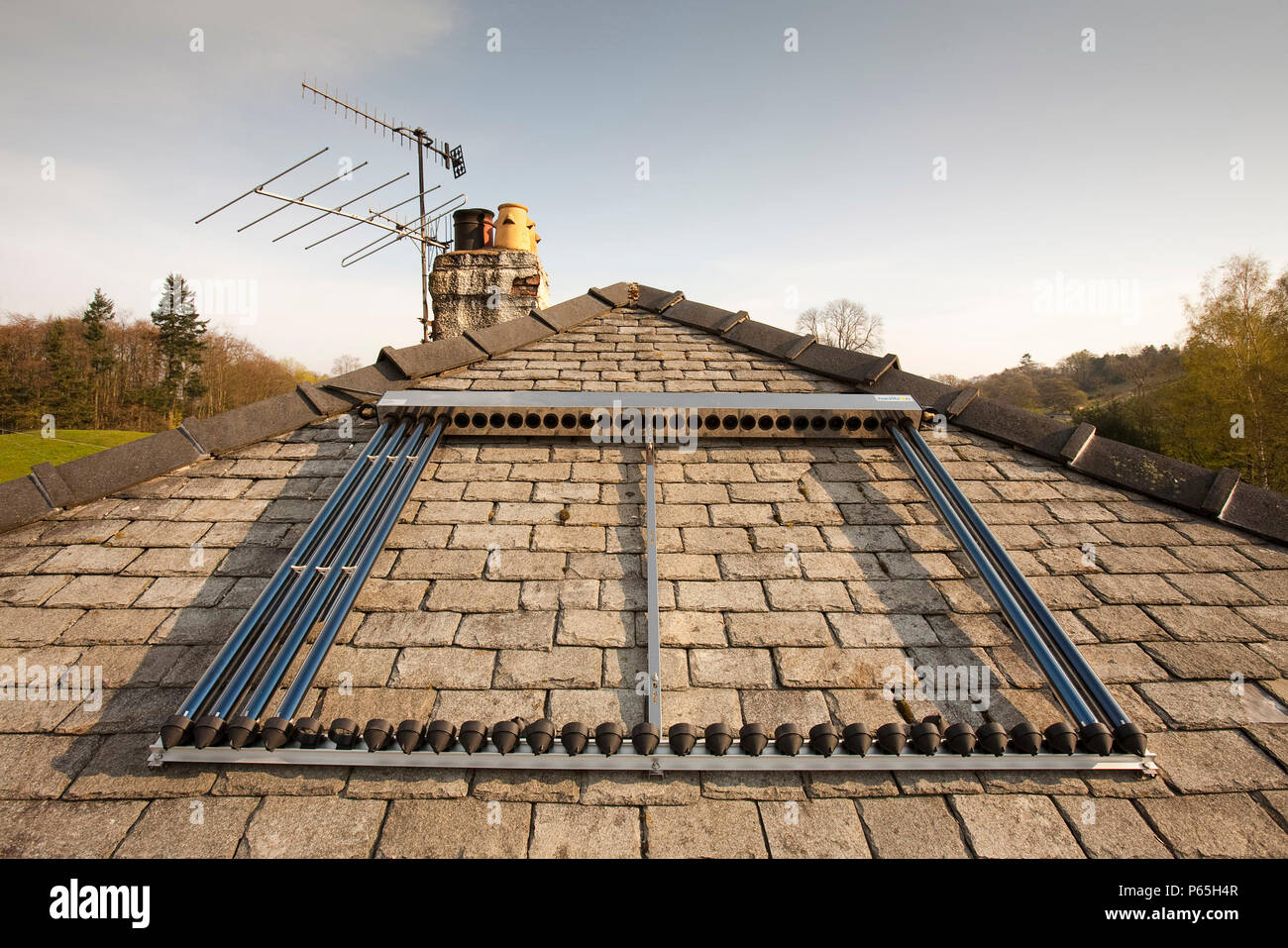 A solar water heating panel being fitted to a house roof in Ambleside ...