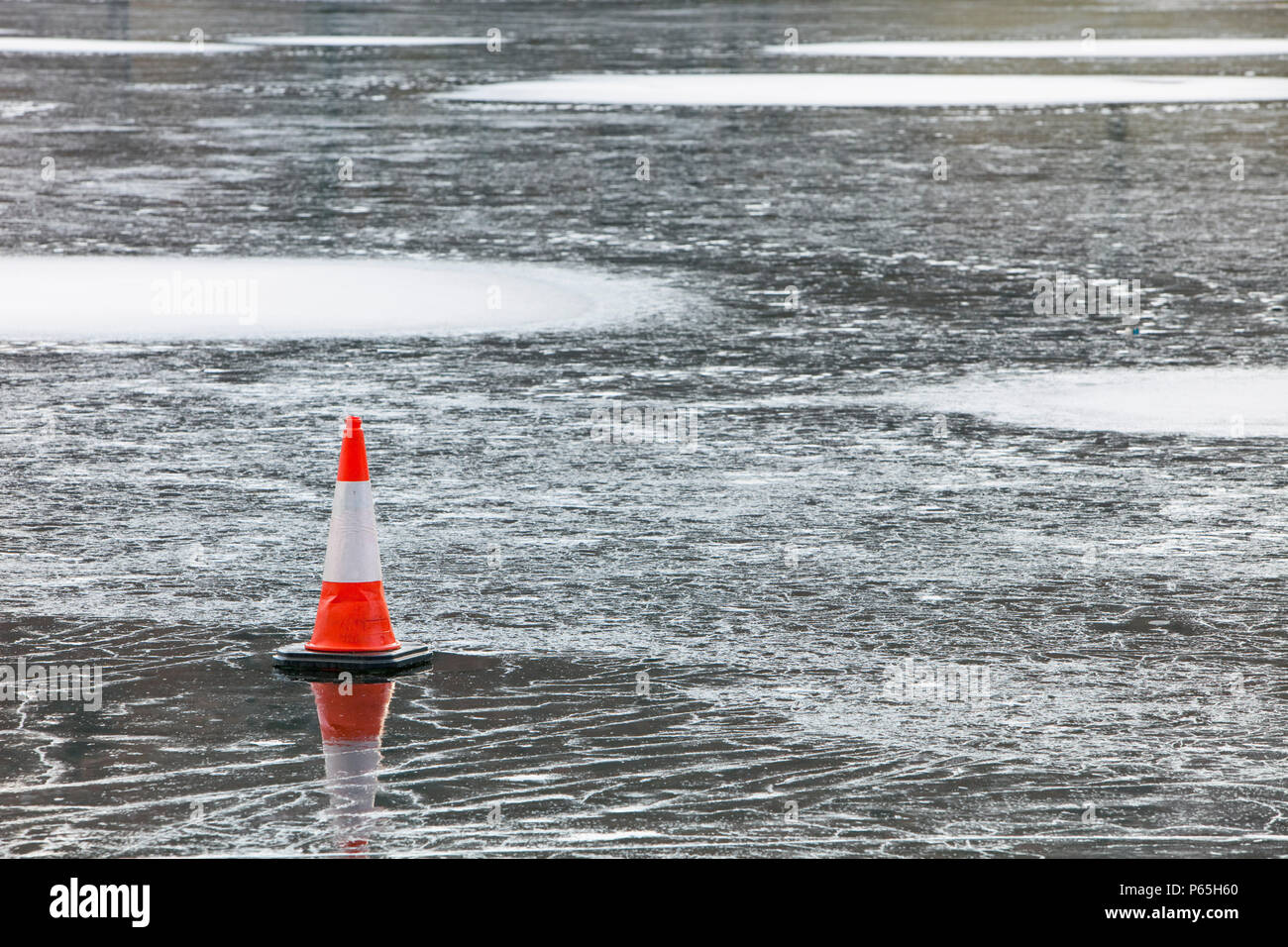 A traffic cone placed on the ice on Rydal Water in the Lake District ...