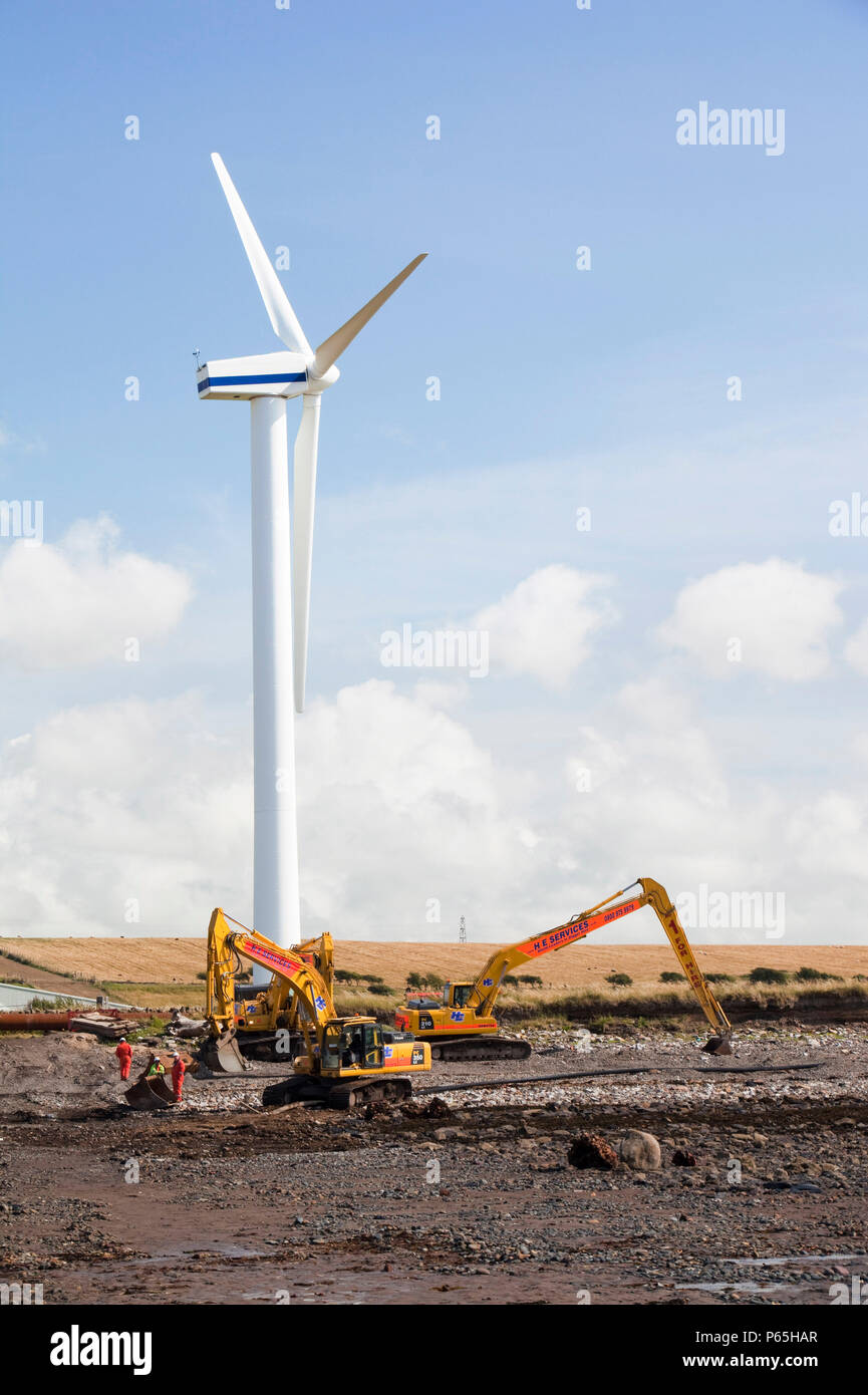 Construction workers working on the foreshore of the Solway Firth near ...