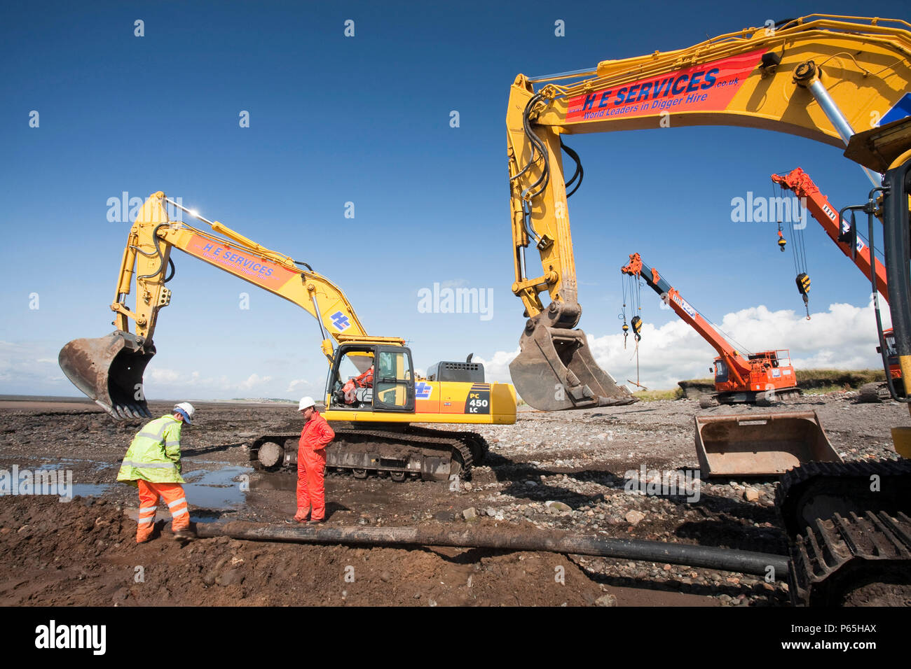 Construction workers working on the foreshore of the Solway Firth near ...