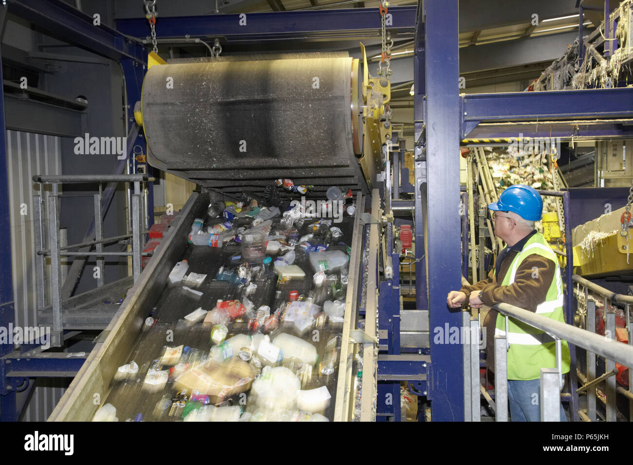 Man watching recycling on conveyor belt Stock Photo - Alamy