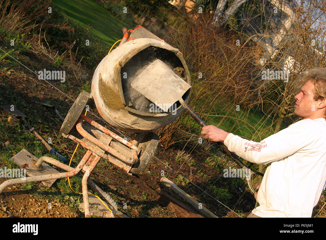 Man shoveling cement hi-res stock photography and images - Alamy