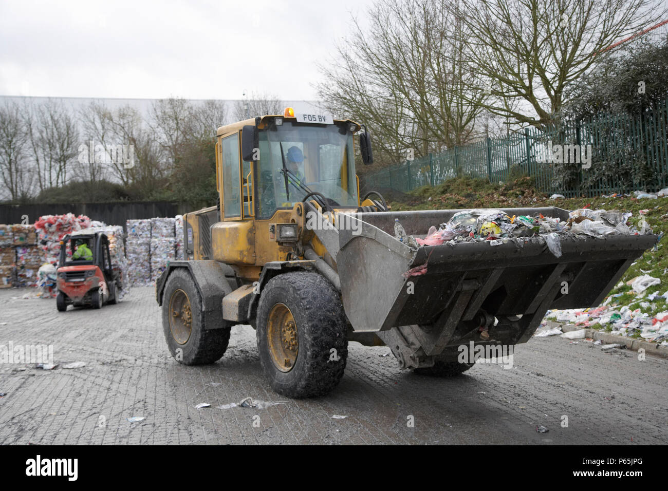 Front loader carrying recycling at recycling plant Stock Photo - Alamy