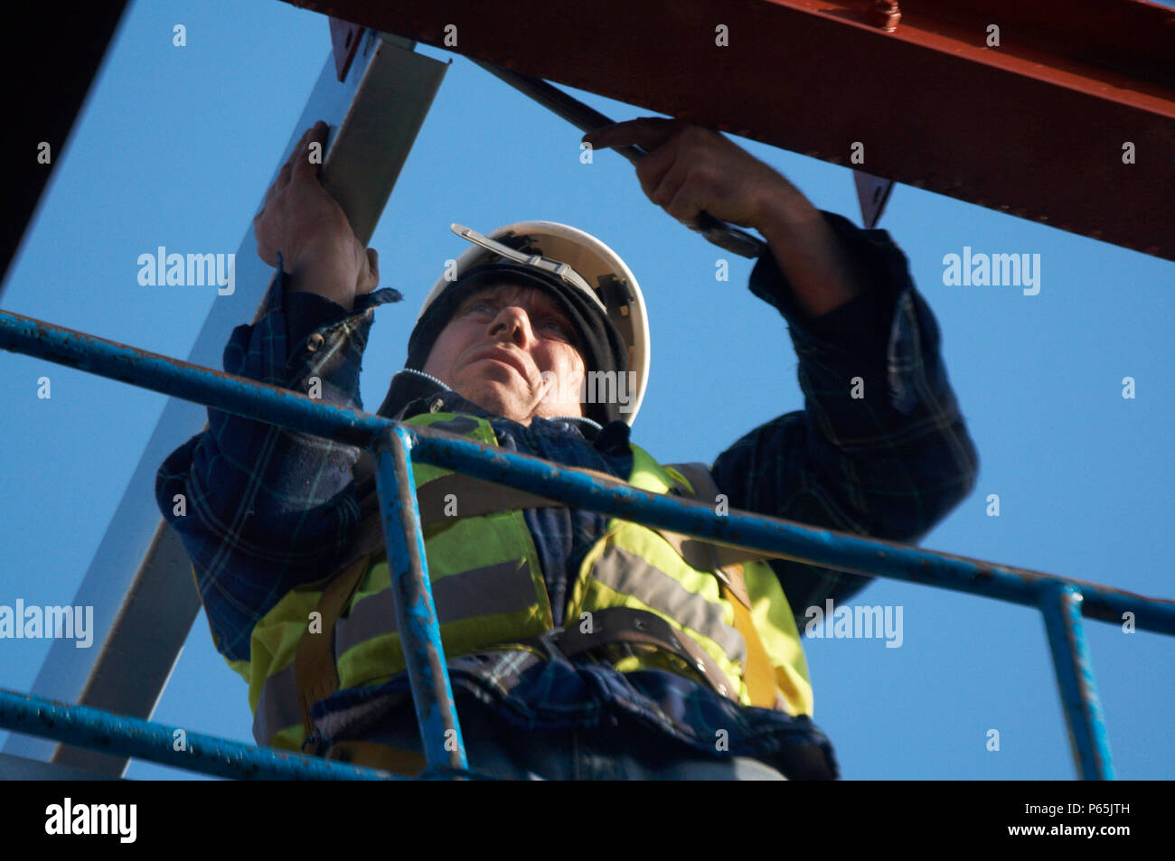 Construction workers on lift platform fixing steel girders Stock Photo ...