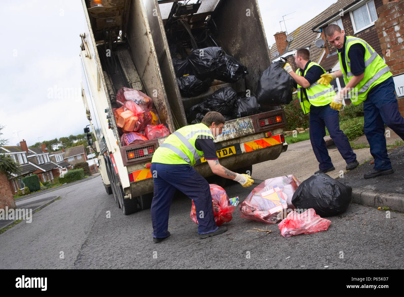Binmen loading rubbish and recycling into dual use rubbish truck Stock ...
