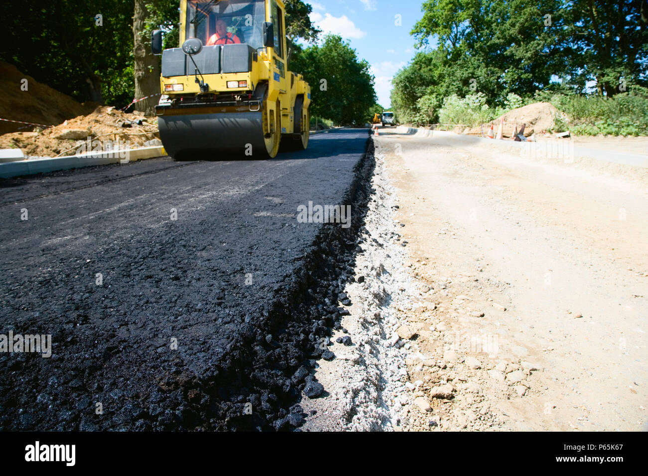 Steamroller flattening tarmac on new road, UK Stock Photo - Alamy