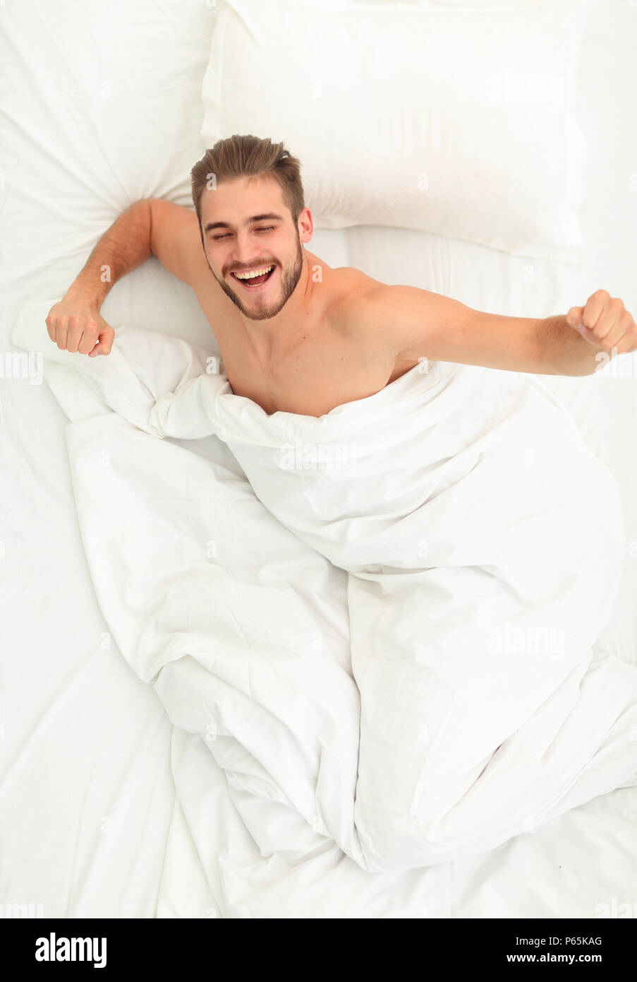 top view. happy man waking up in a comfortable bed Stock Photo - Alamy