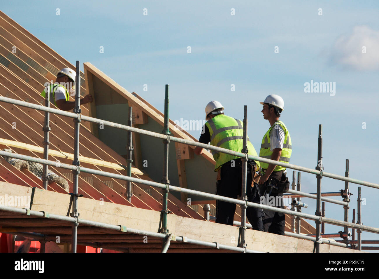 Construction workers installing pre-fabricated section at new housing ... Construction workers installing pre-fabricated section at new housing ...