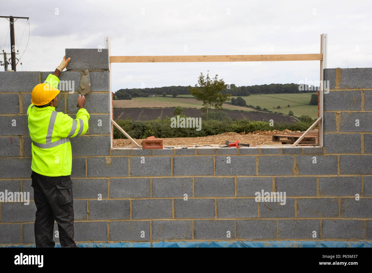 Bricklayer laying breezeblocks, England, UK Stock Photo - Alamy