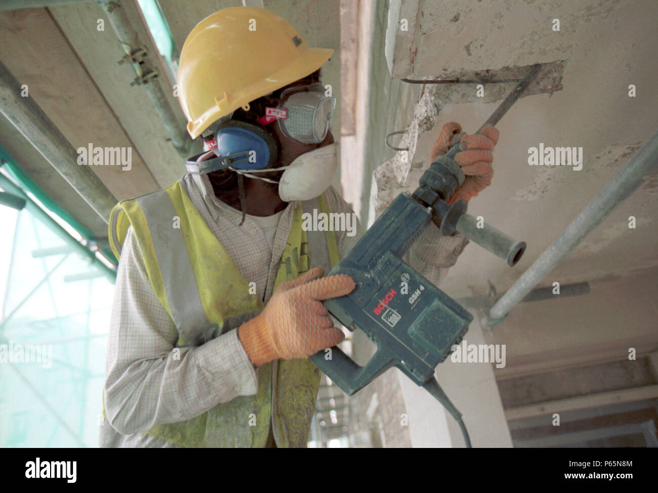 Concrete Repairs. Operative breaking concrete from scaffolding Stock ...