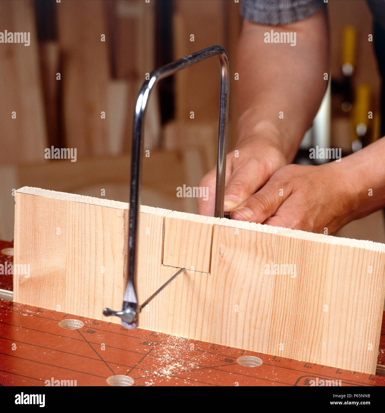 Cutting a plank of wood with a saw Stock Photo - Alamy