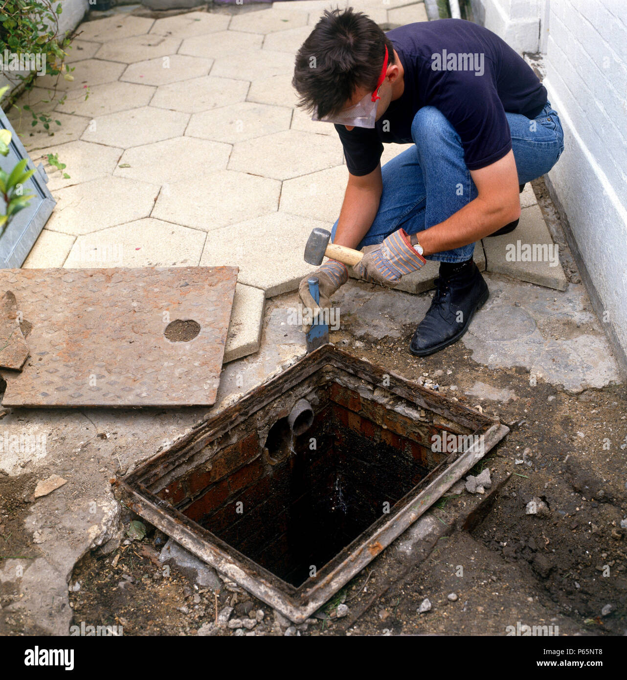 Installing a manhole cover over the drain Stock Photo - Alamy