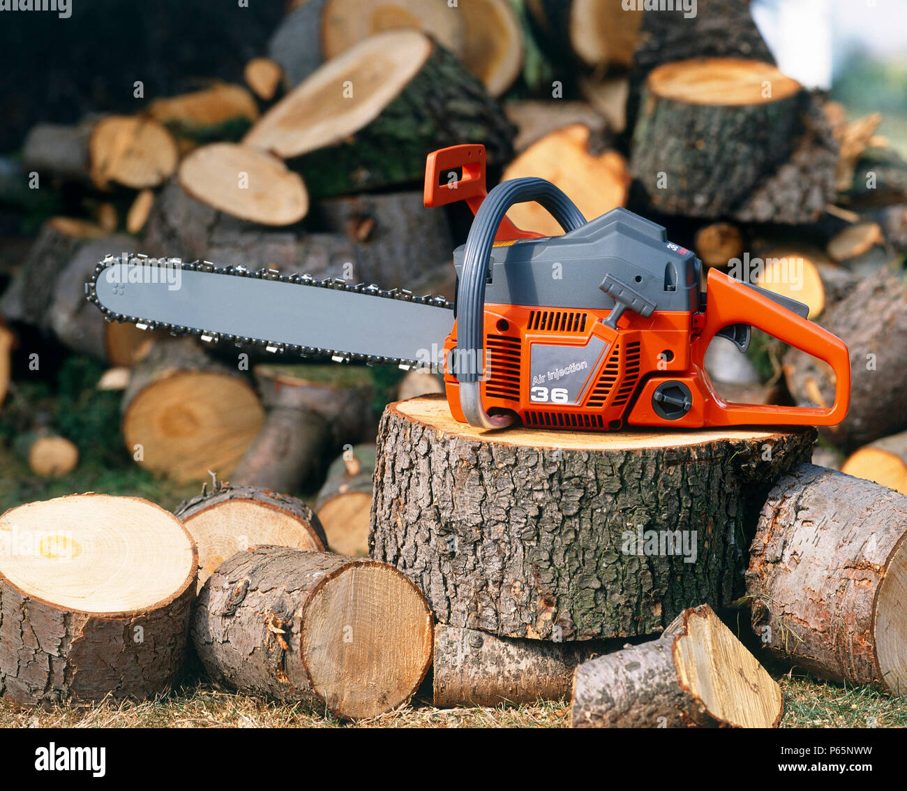 Logs and chainsaw Stock Photo - Alamy