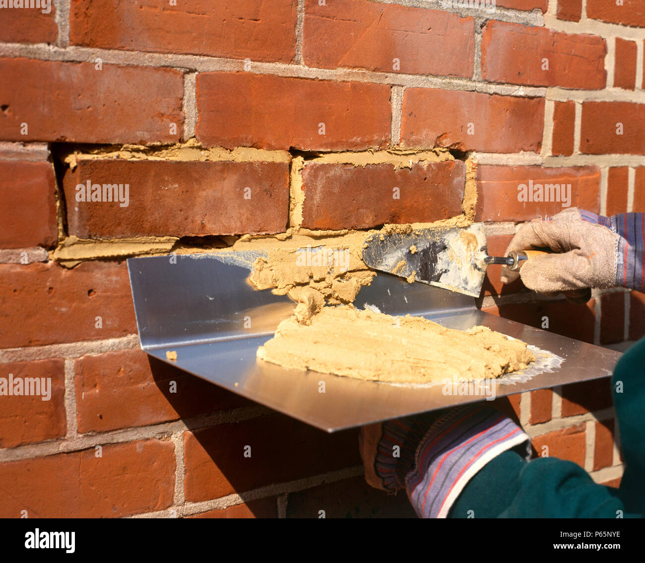 Replacing a brick in a wall Stock Photo - Alamy