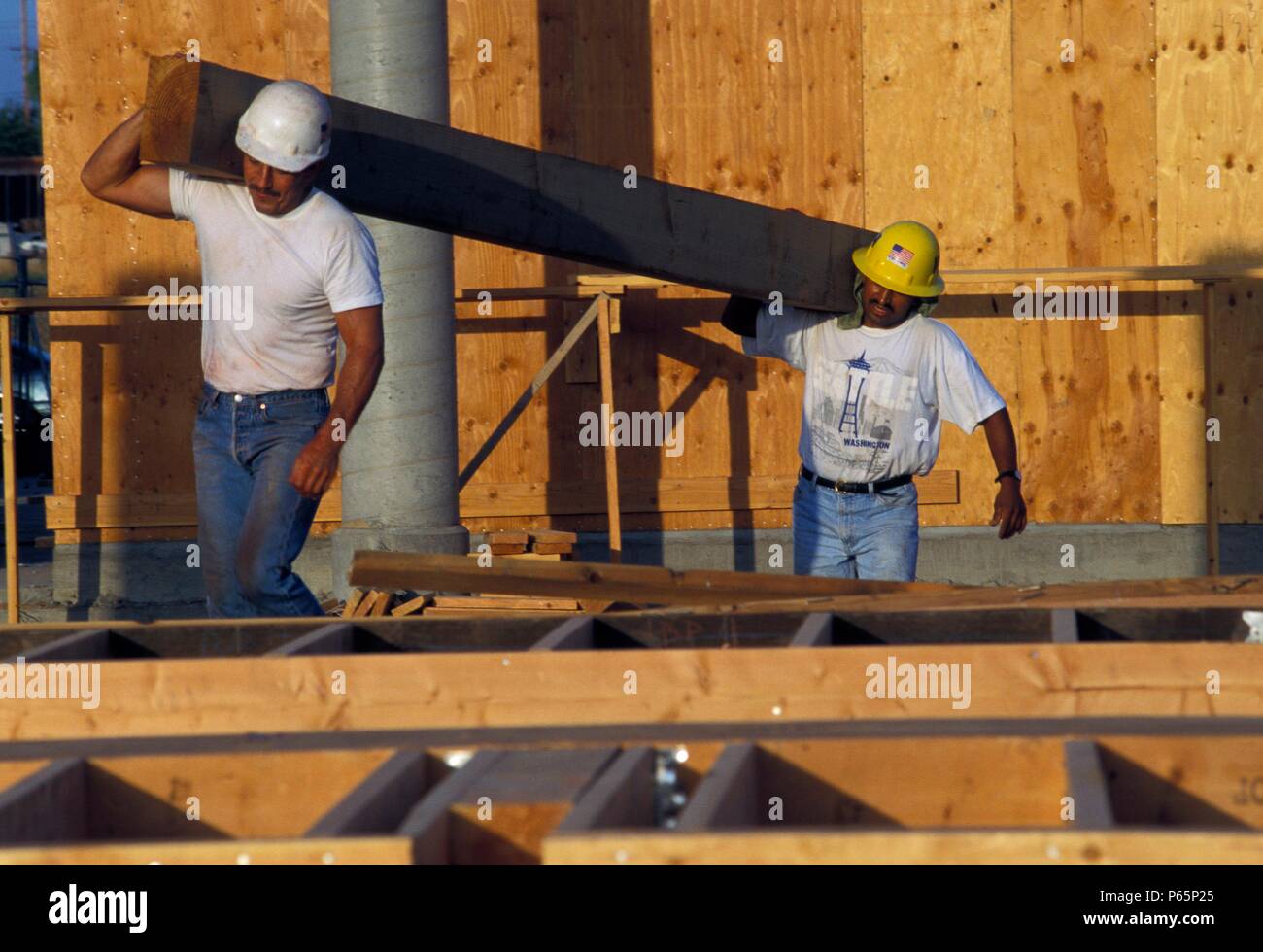 Two carpenters carrying large wooden beam Stock Photo - Alamy