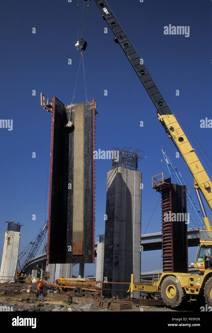 Using crane to move bridge column concrete forms from completed column ...