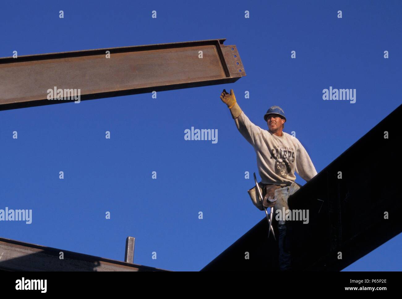 Ironworker connector reaching for beam to guide it into position, beam ...
