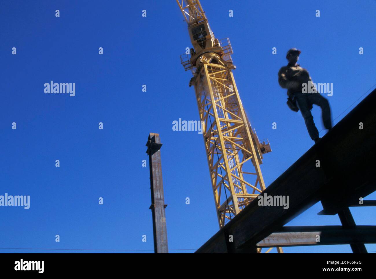 Ironworker walking beam of steel high rise building framework, with ...