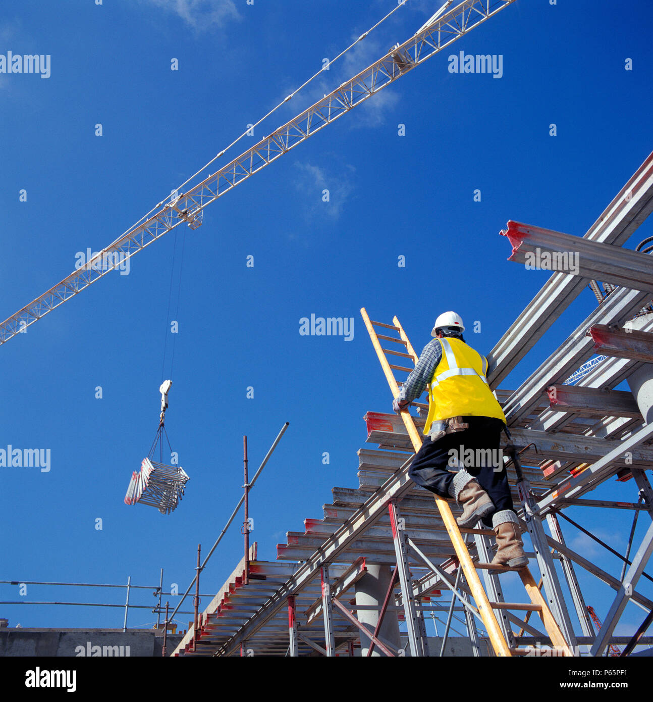 Construction worker climbing a ladder Stock Photo - Alamy
