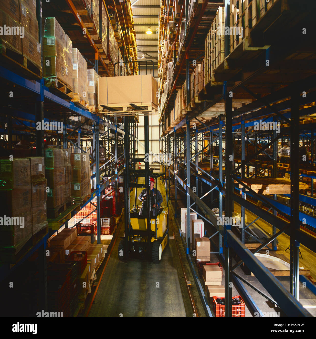 Fork lift truck lifting box in warehouse, UK Stock Photo - Alamy