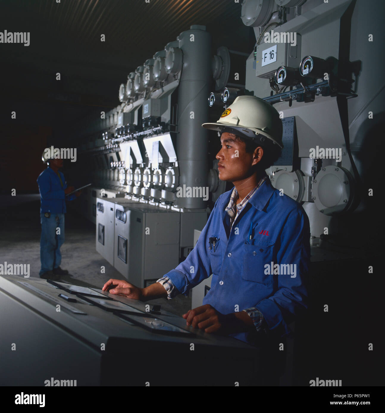 Man at control panel in power station, Brunei Stock Photo - Alamy