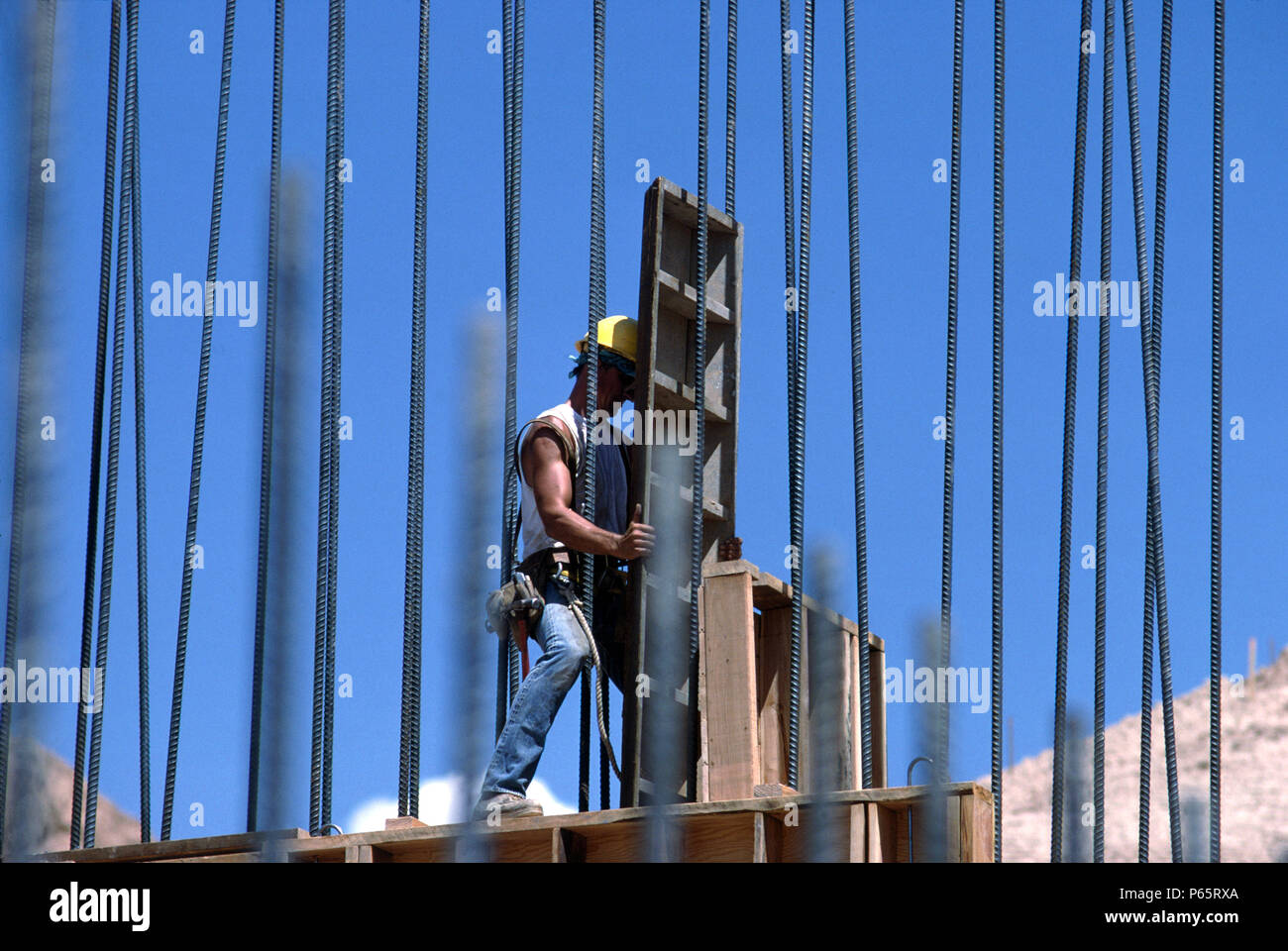 Worker positioning temporary timber shuttering for reinforced in situ ...