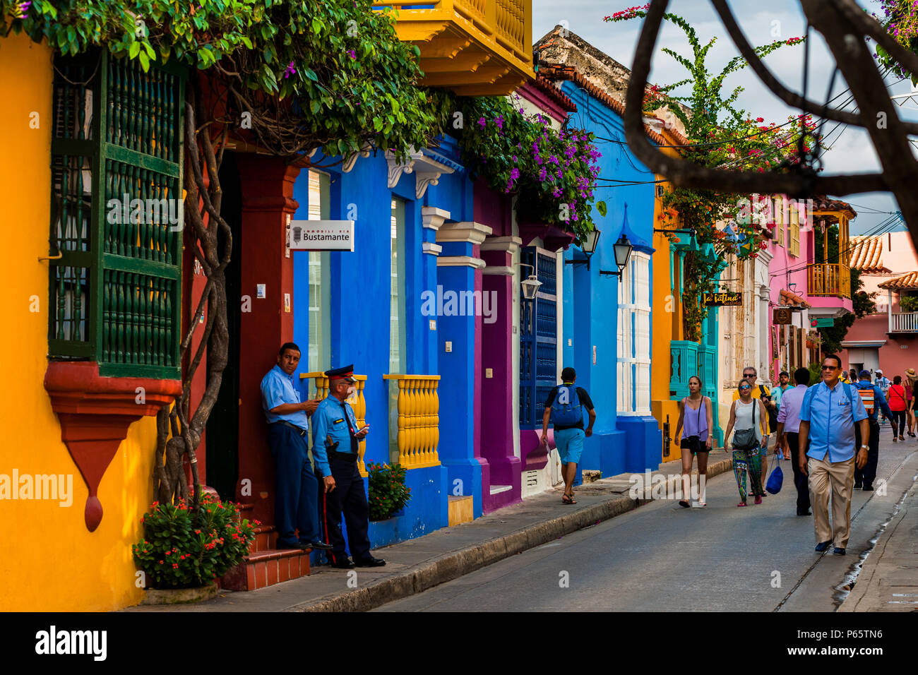 Tourists walk along the colorfully painted colonial houses in the ...