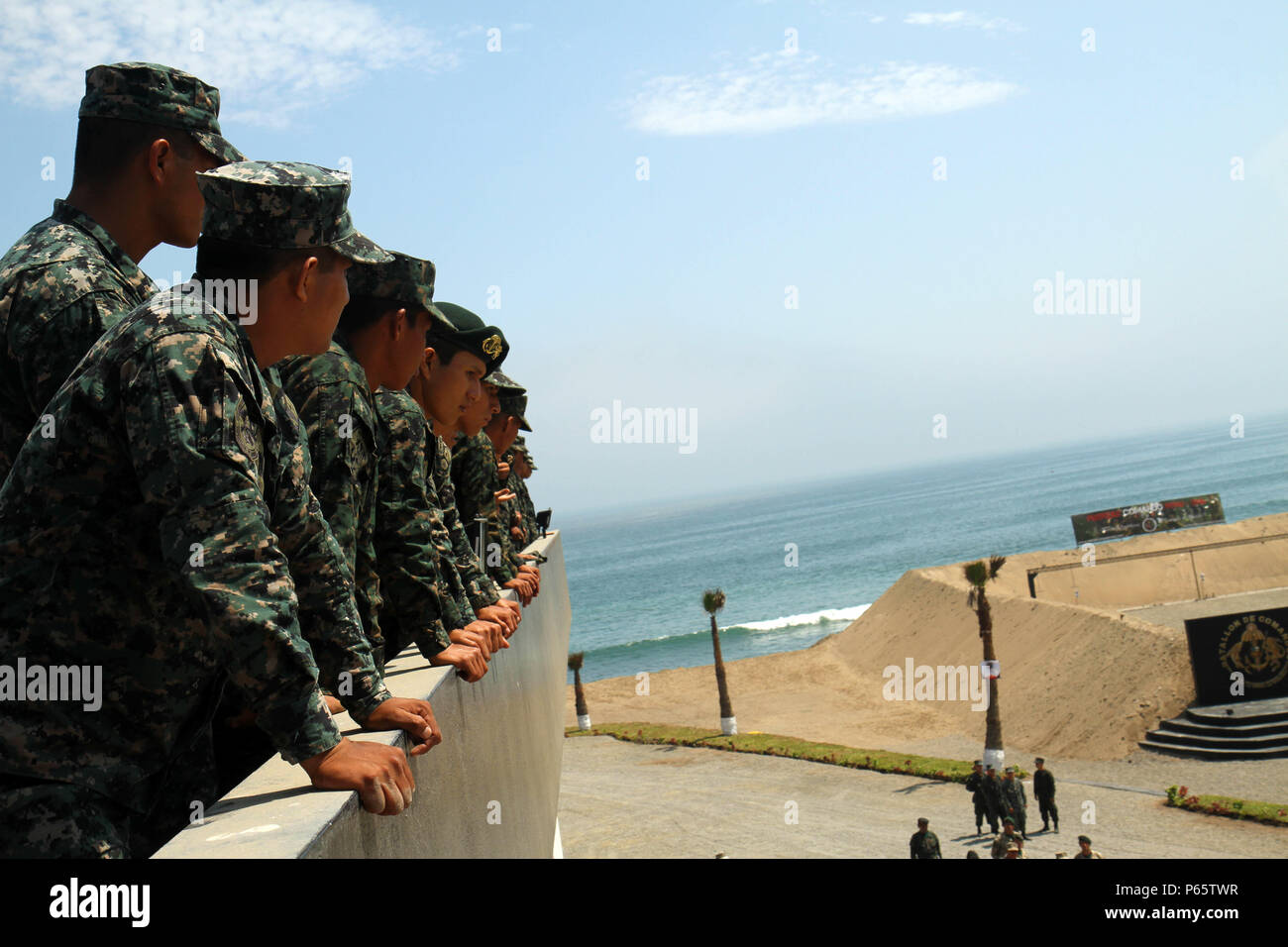 Peruvian soldiers watch a physical training test from atop a building ...