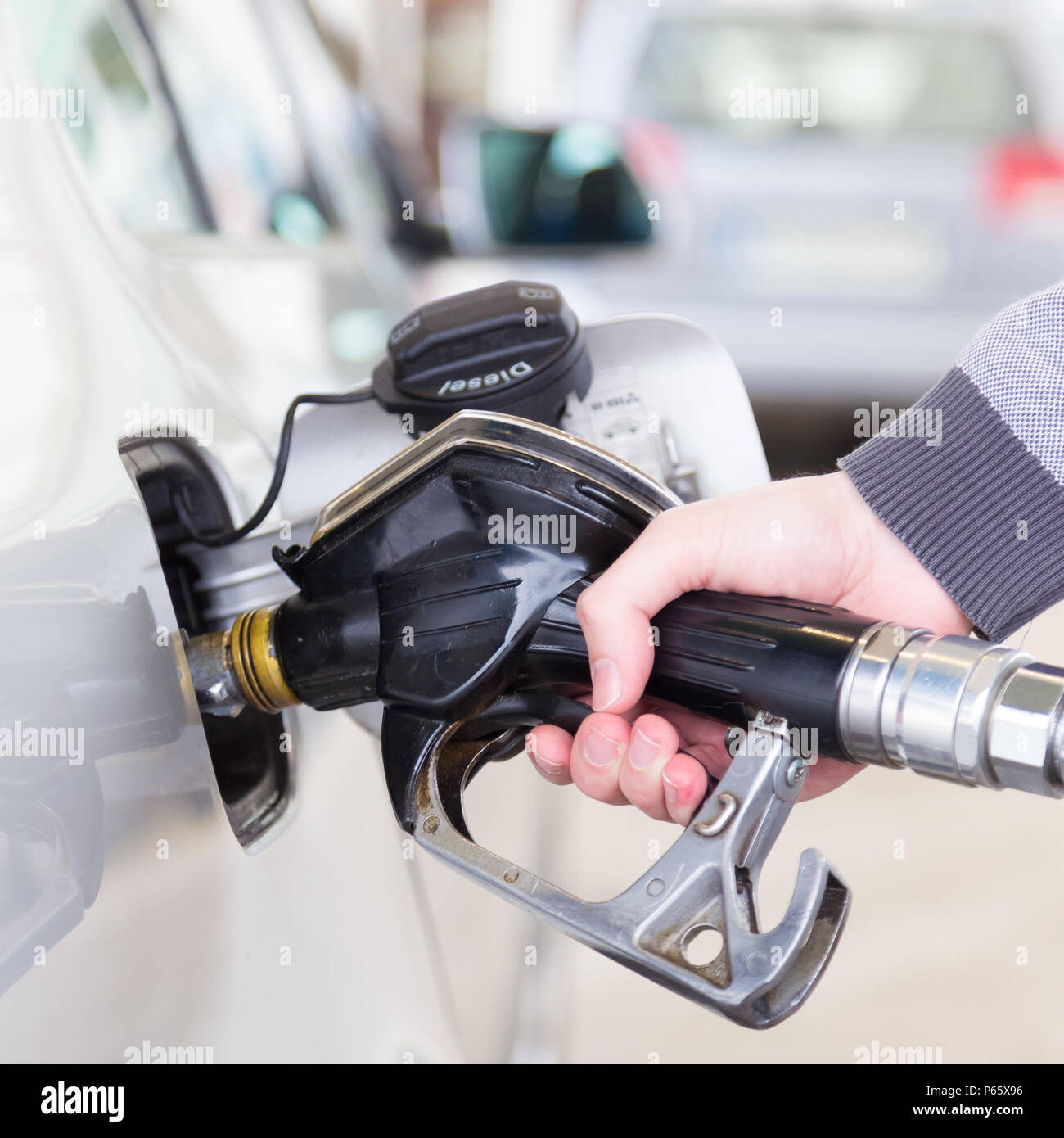 Pumping gas at gas pump. Closeup of man pumping gasoline fuel in car at ...