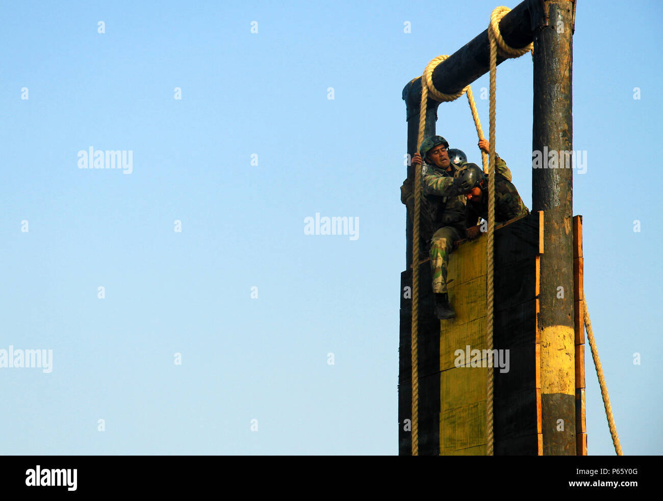 Team Uruguay climbs over a rope wall during the Fuerzas Comando ...
