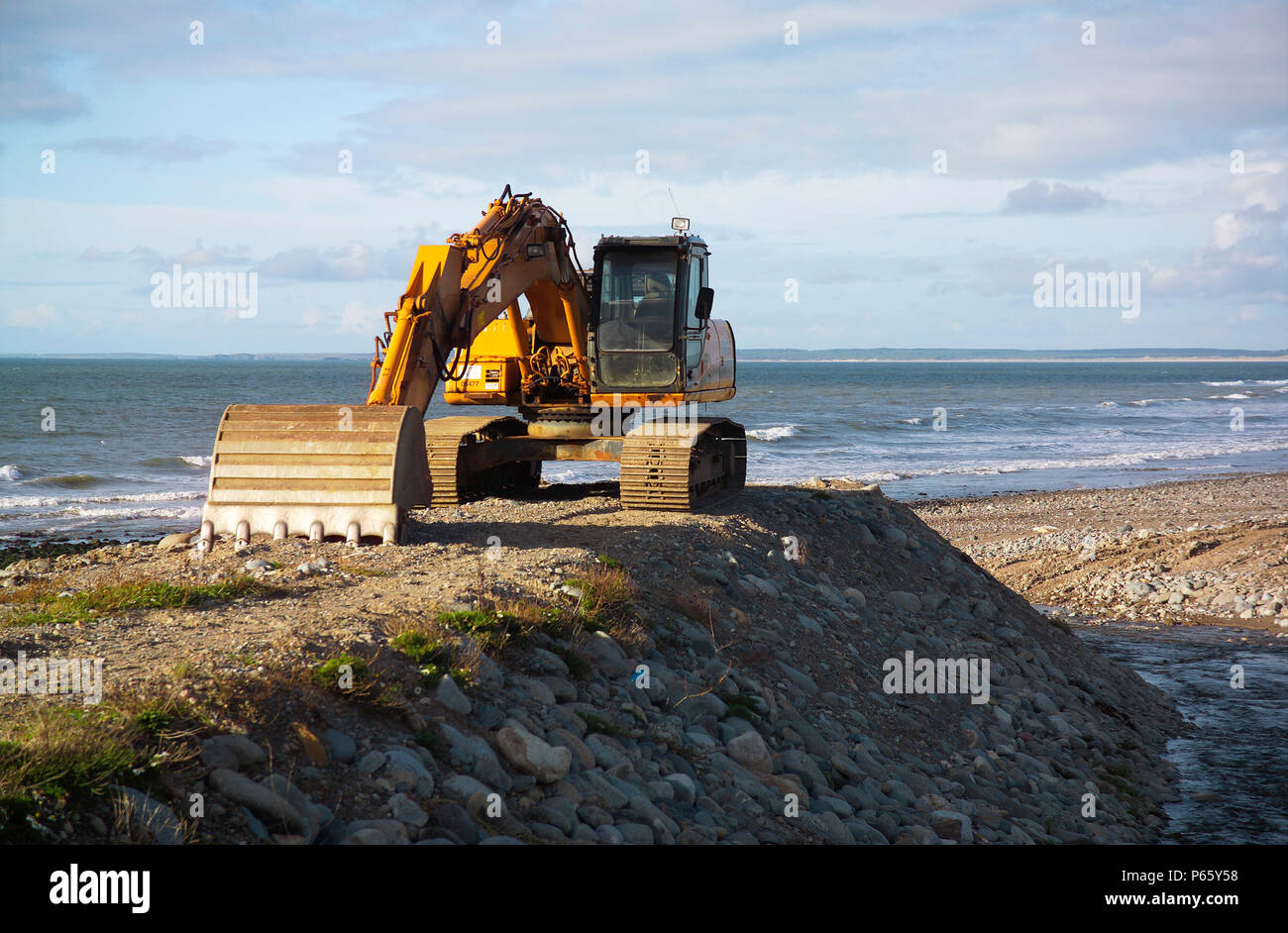 Digger on the beach at Aberdesach, North West Wales Stock Photo - Alamy