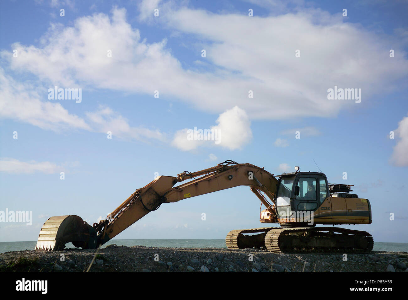 Digger on the beach at Aberdesach, North West Wales Stock Photo - Alamy