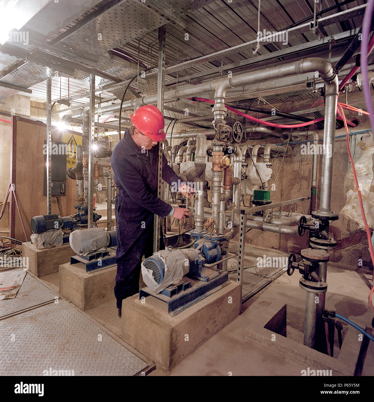 Worker checking pipework Stock Photo - Alamy