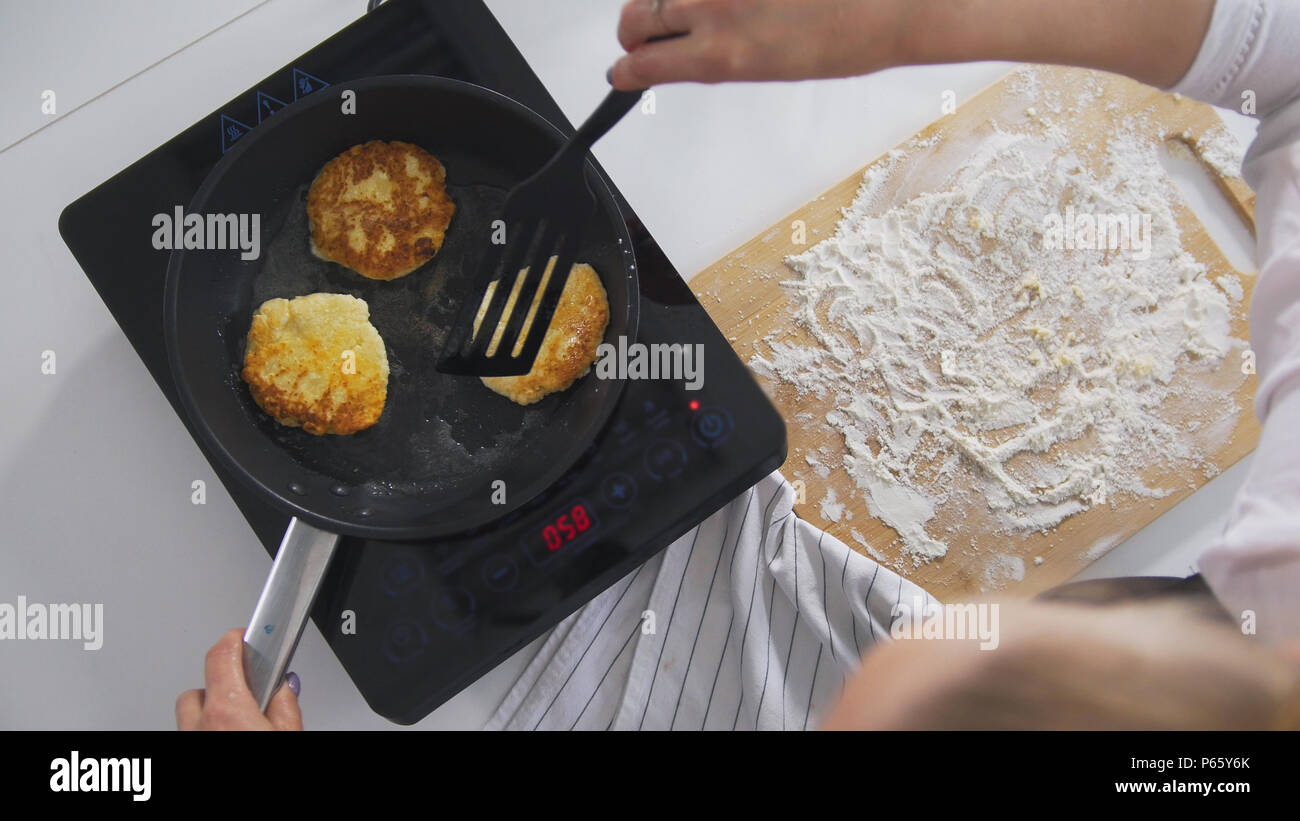 Female hands fries in the pan homemade cottage cheese pancakes Stock ...