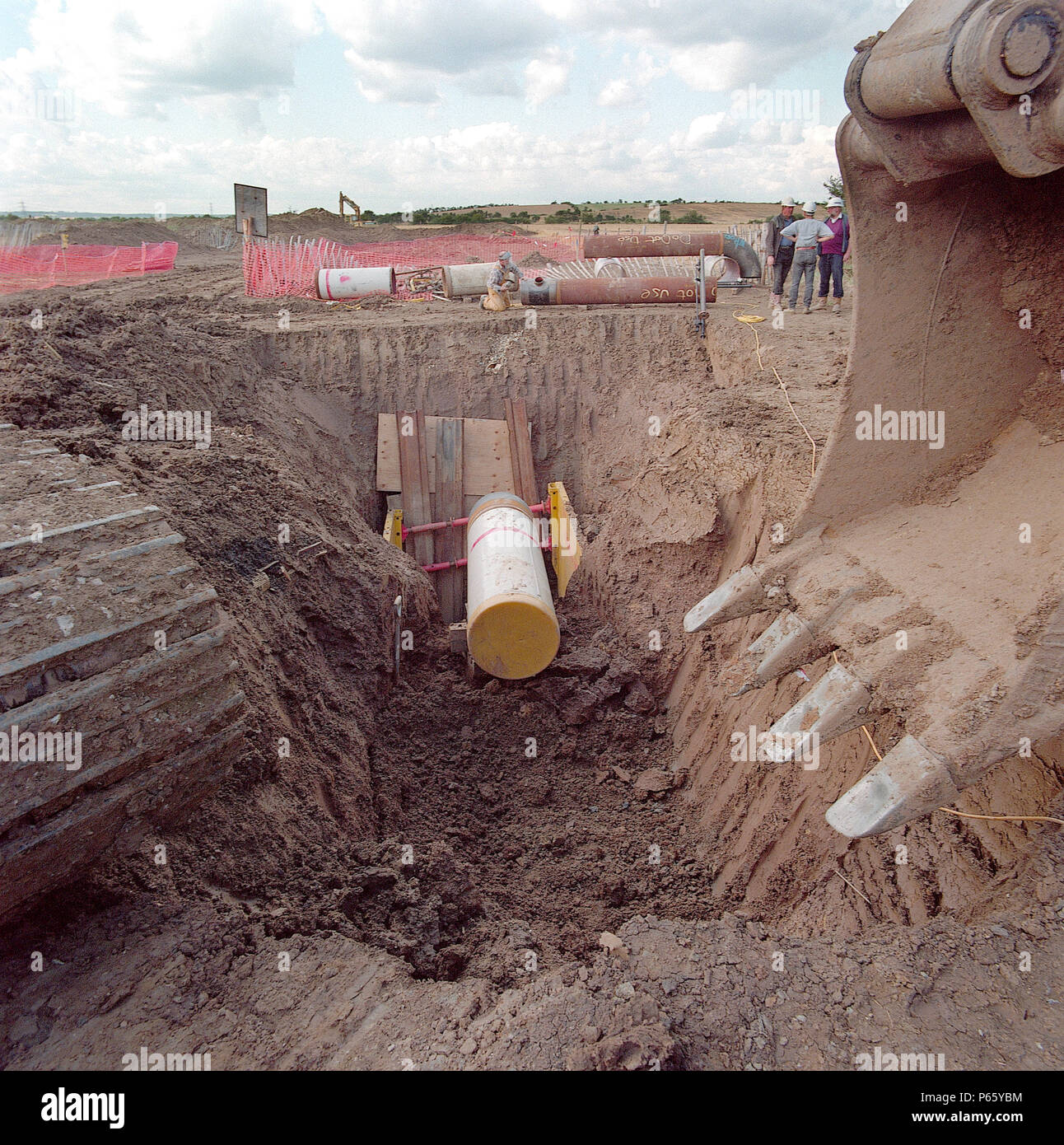 Excavating trench on the Essex marshes to install gas supply pipework ...