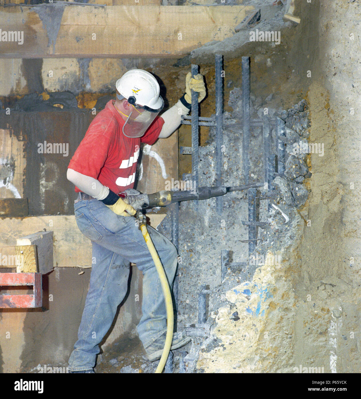 Construction Worker demolishing a reinfoced concrete rebar witha ...