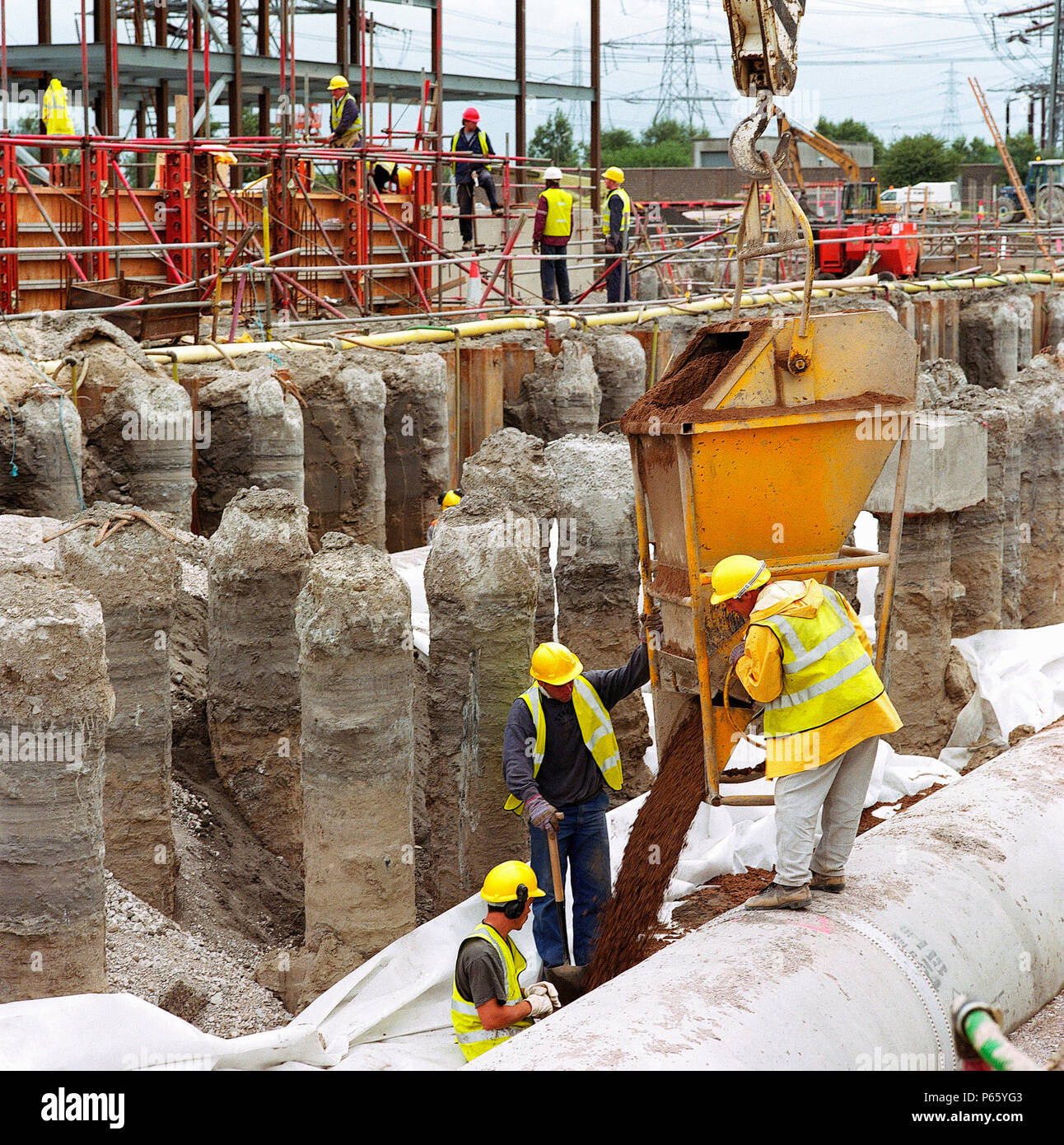 Placing concrete from hopper to haunch of precast concrete pipe ...