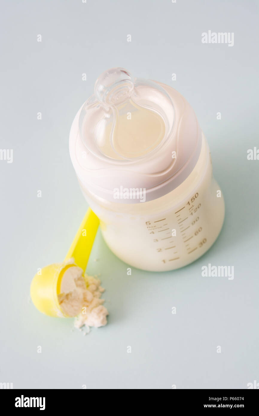 Baby bottle and milk on gray background Stock Photo - Alamy
