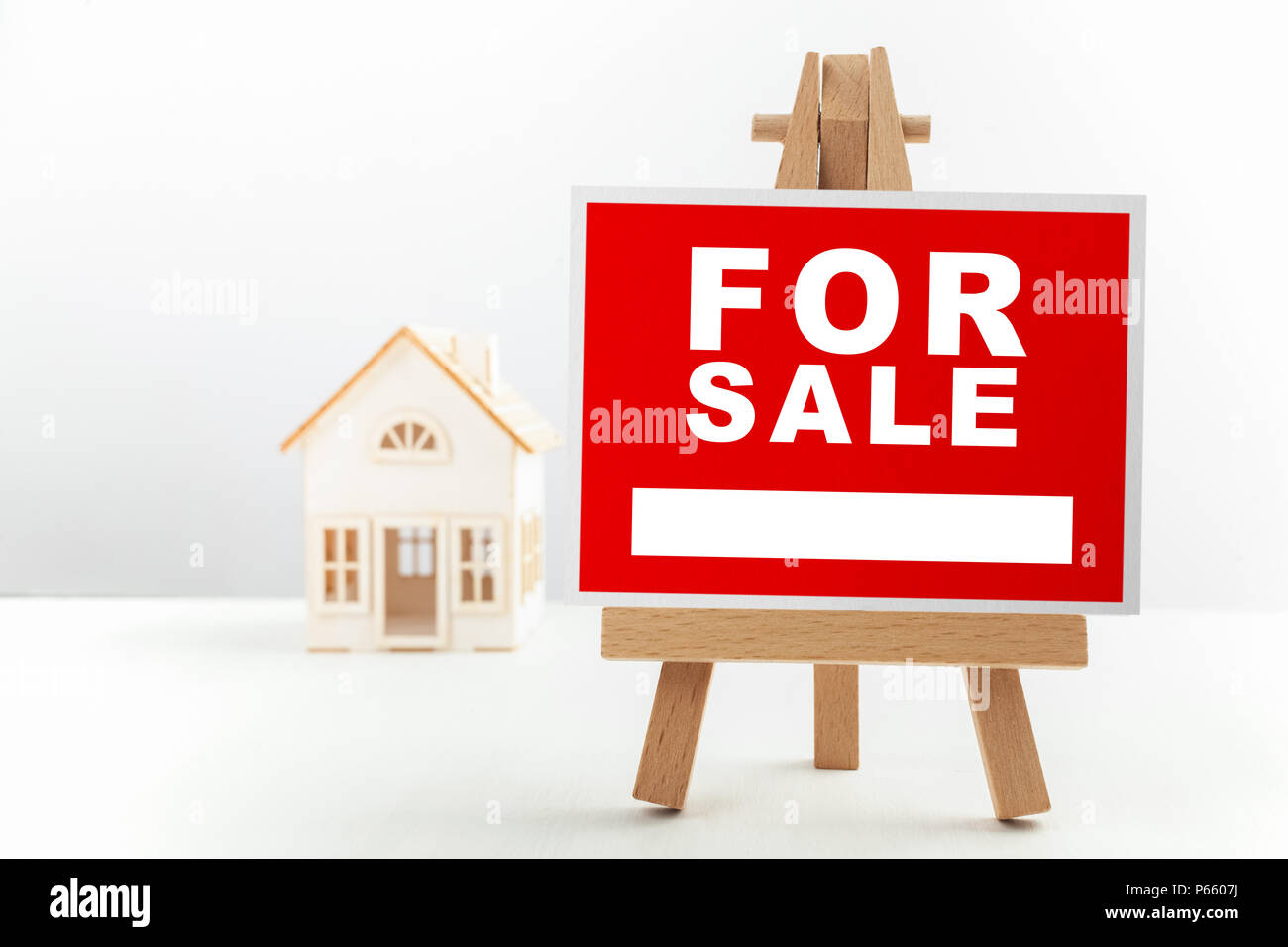 Red For Sale Real Estate Sign in Front of Small House Stock Photo - Alamy