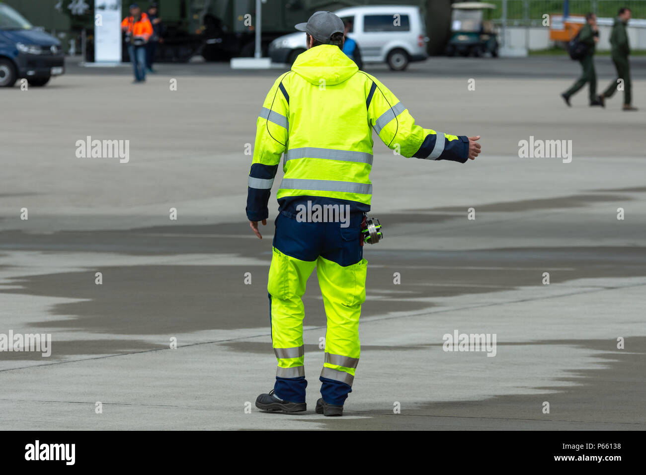 A flight safety officer in light-reflecting clothing on the airfield ...