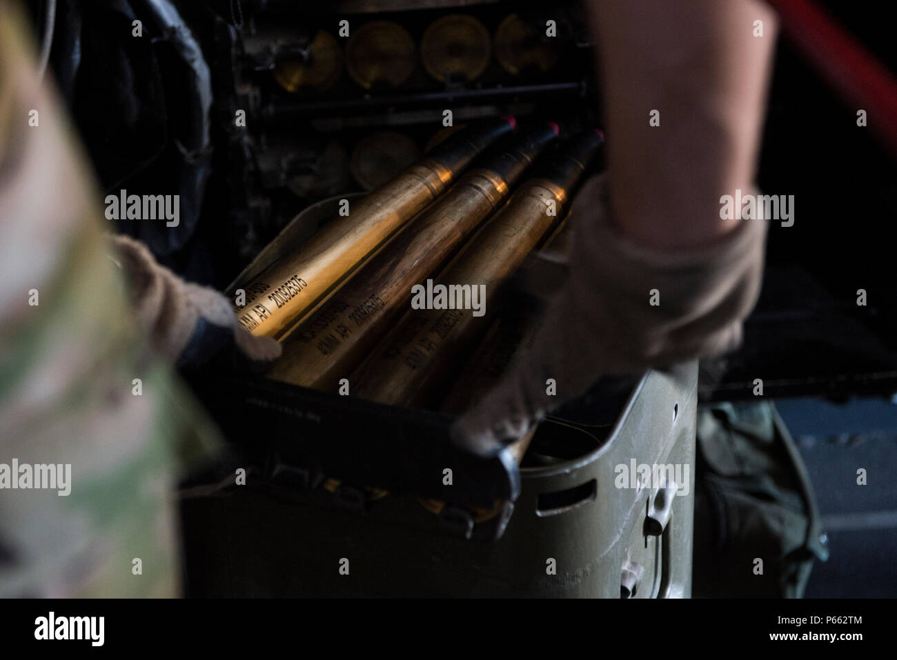 An aerial gunner with the 4th Special Operations Squadron, loads 40mm ...