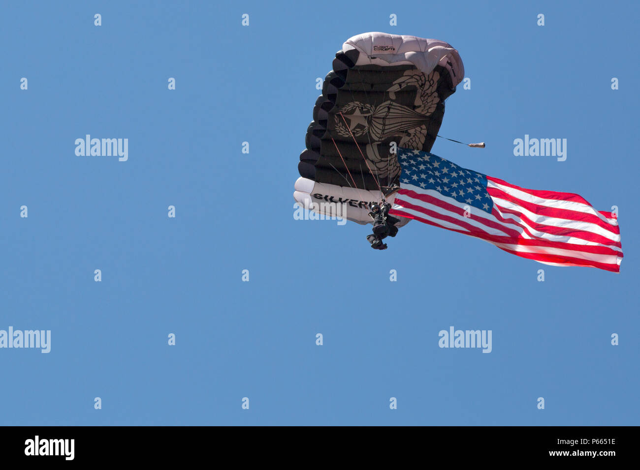 A member of the Silver Wings parachute team descends from a UH-60 Black ...