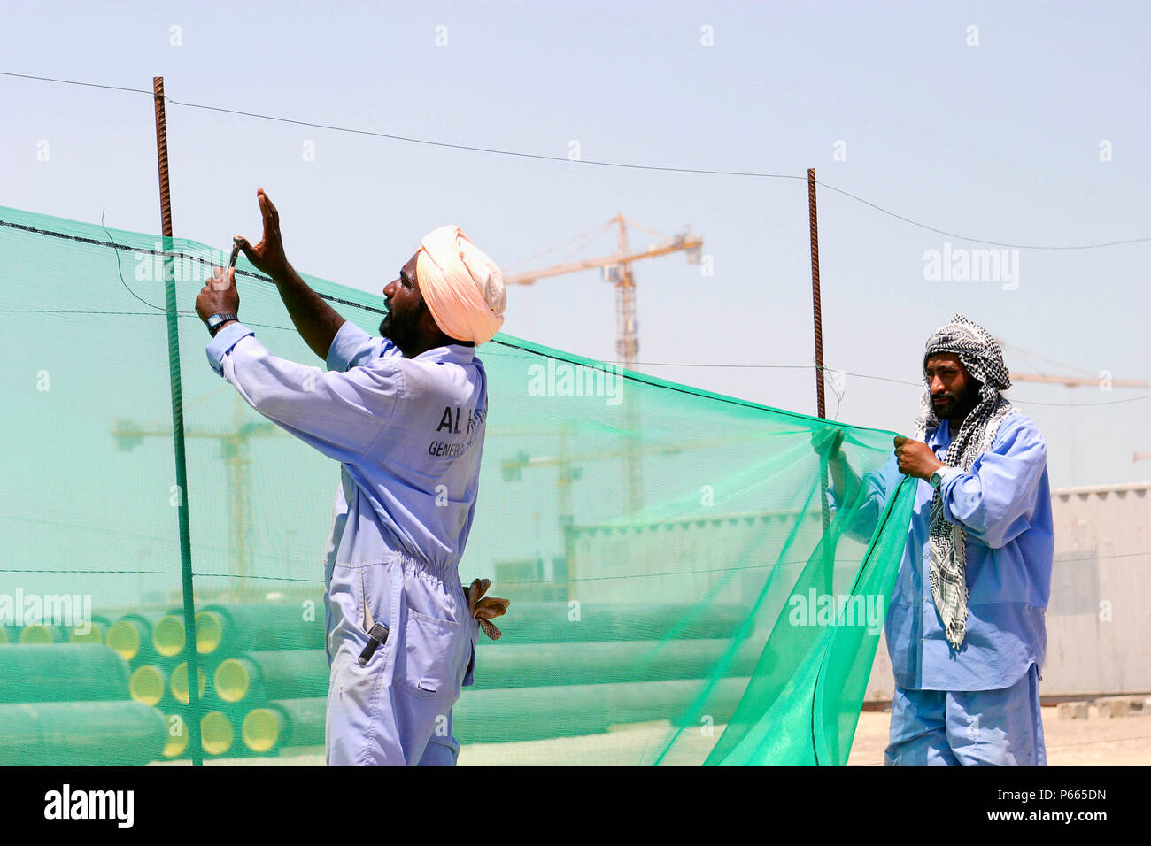 Construction Workers putting up a fence Stock Photo - Alamy