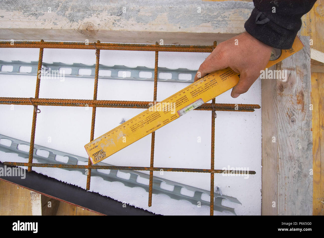 Carpenter using level with wood and rebar Stock Photo - Alamy