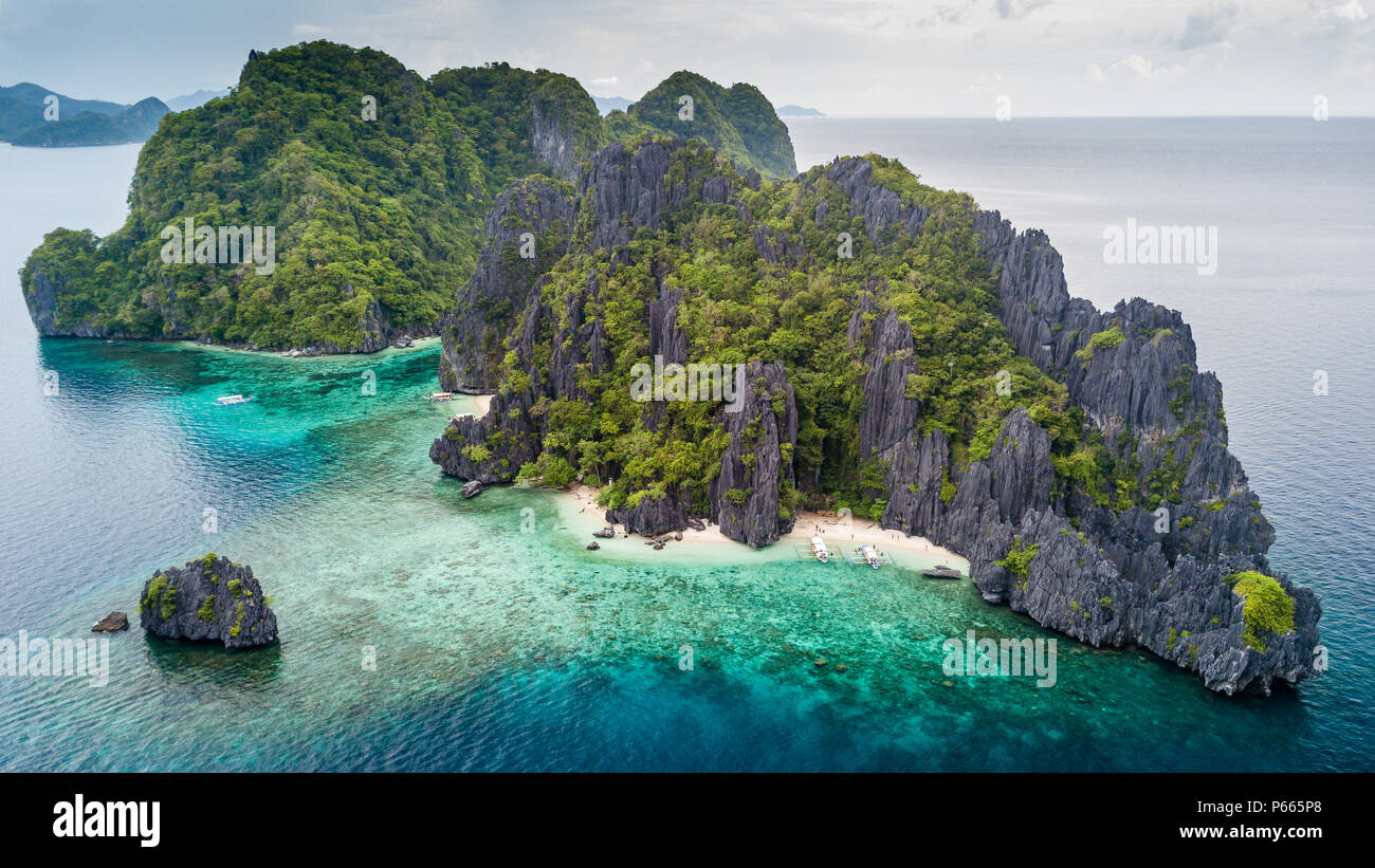 Aerial drone view of a tiny tropical island with beach, coral reef and ...