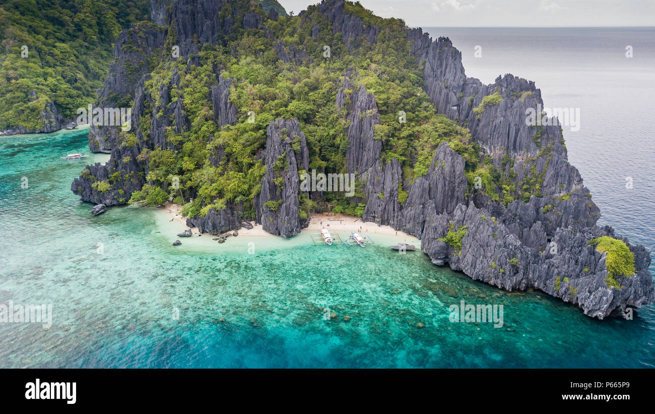 Aerial drone view of a tiny tropical island with beach, coral reef and ...