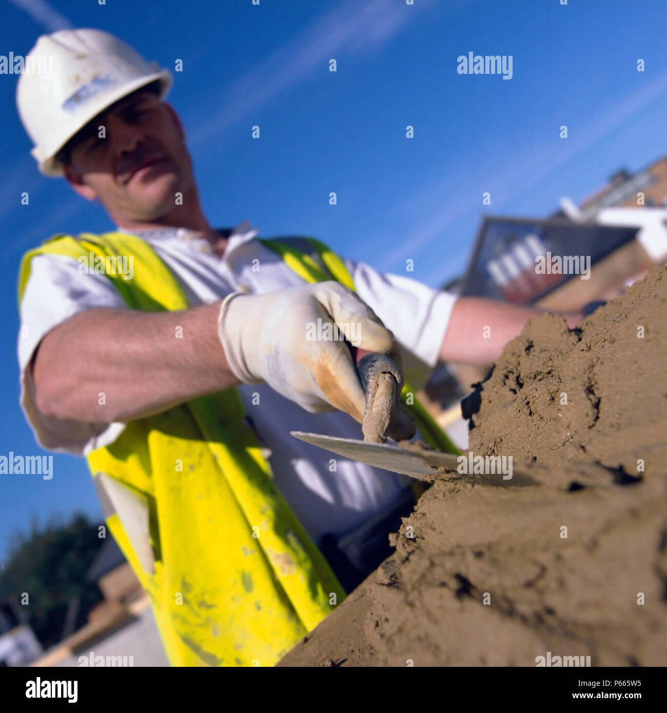 Bricklayer applying cement onto bricks Stock Photo - Alamy
