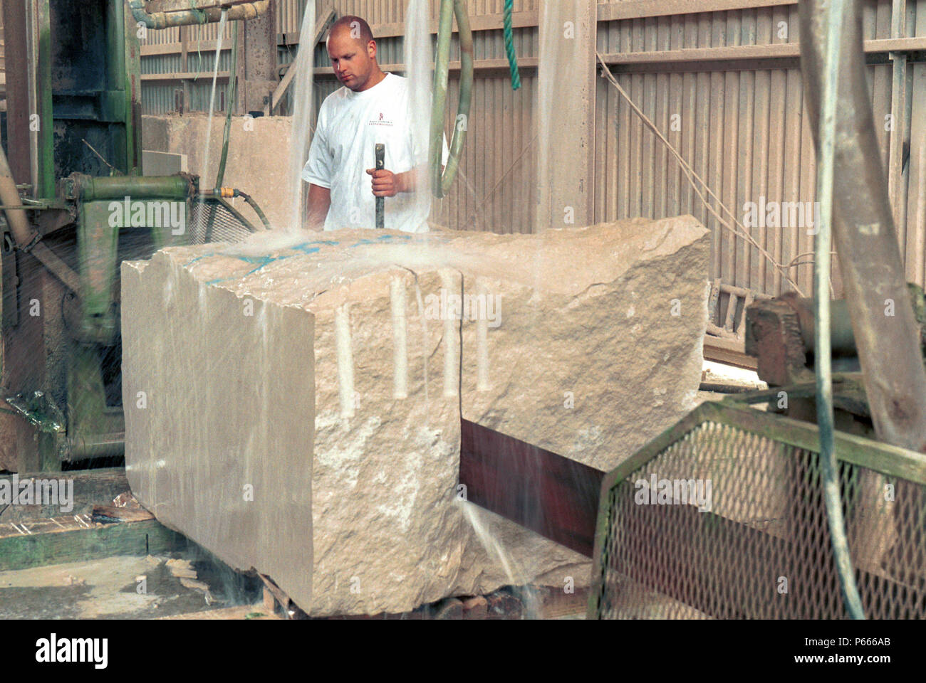 Stonemasonery. Banking work. Working on a piece of stone on a stand ...
